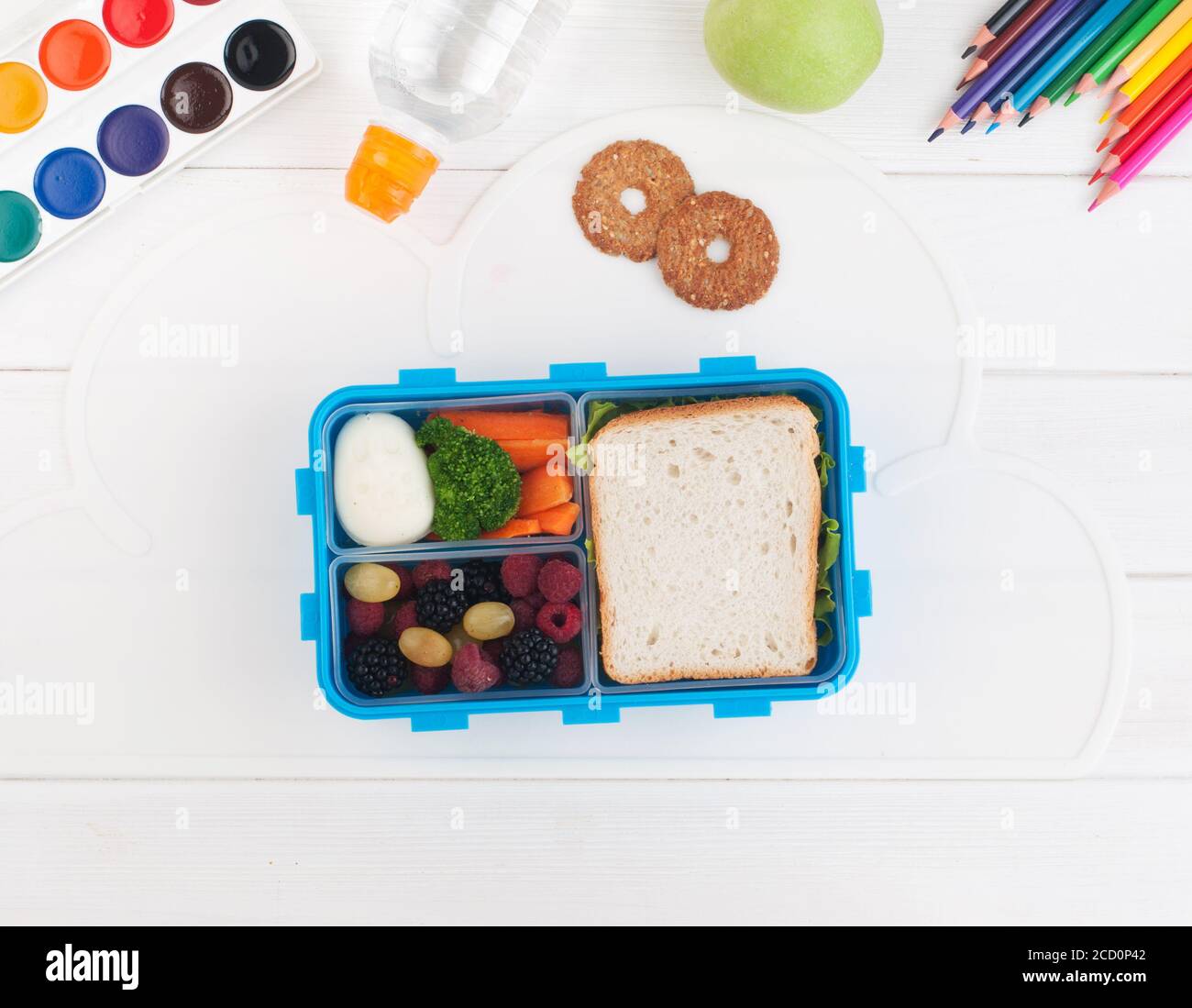 Open lunch box with sandwich, vegetables, egg, fresh berries on the ...
