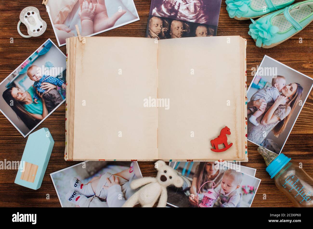 Open vintage album with mother and baby pictures and accessories on ...