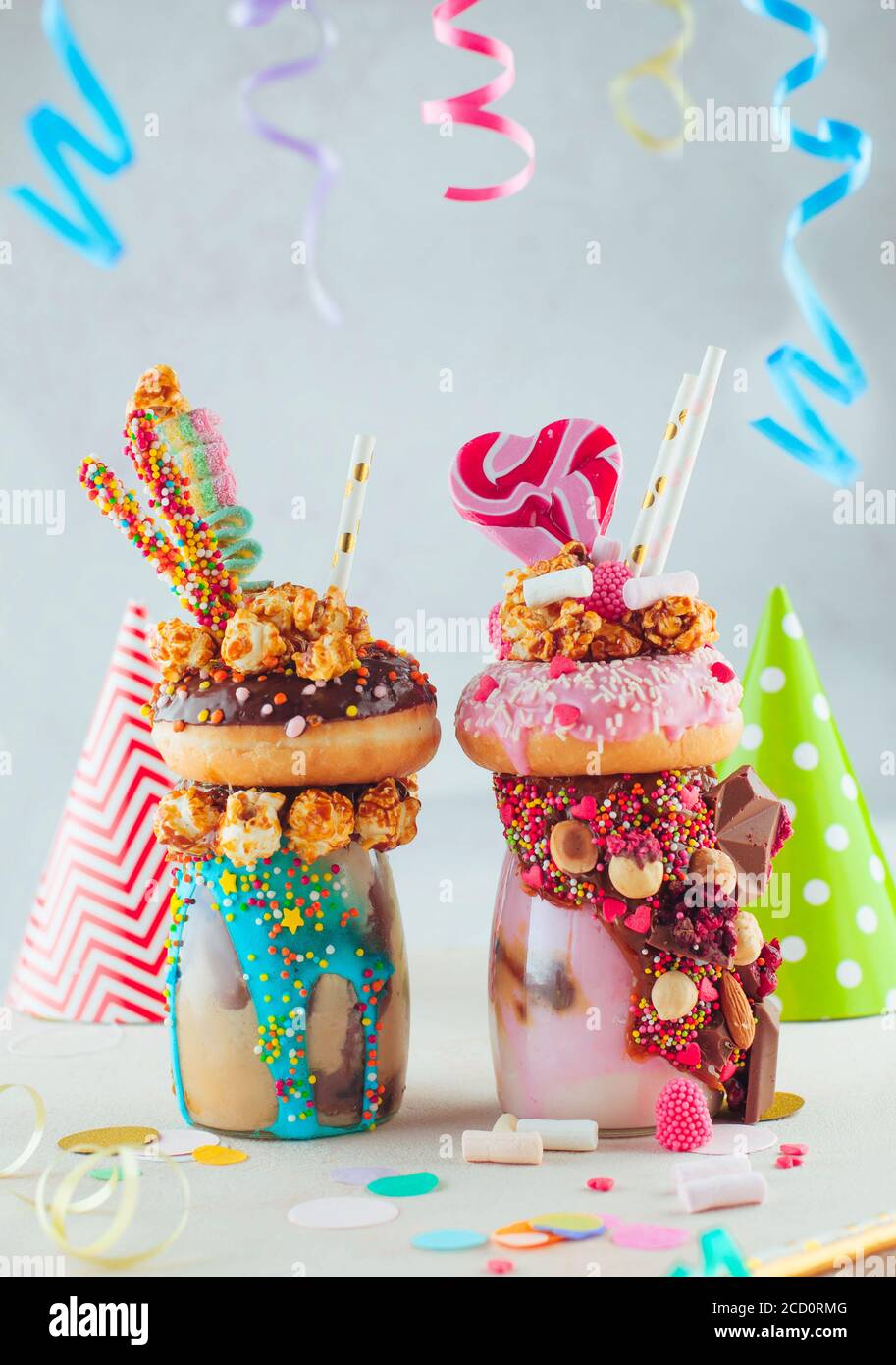 Two freak shakes topping with donuts, caramel popcorn and sweets on the ...