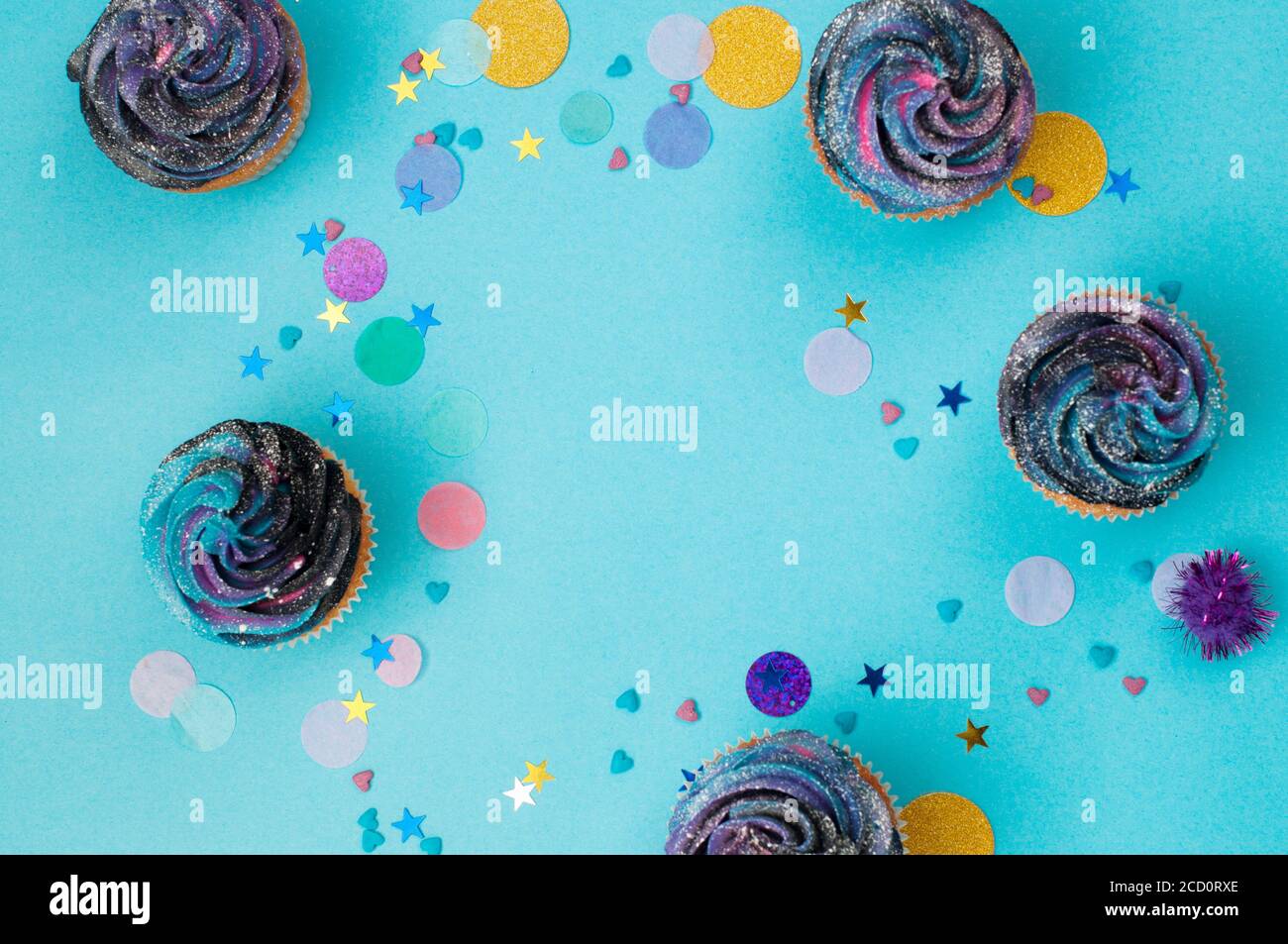 Vanilla cupcakes with galaxy dark whipped cream on party background ...