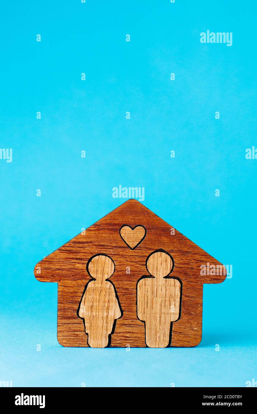 Family home concept. Wooden house with figures of man and woman inside ...