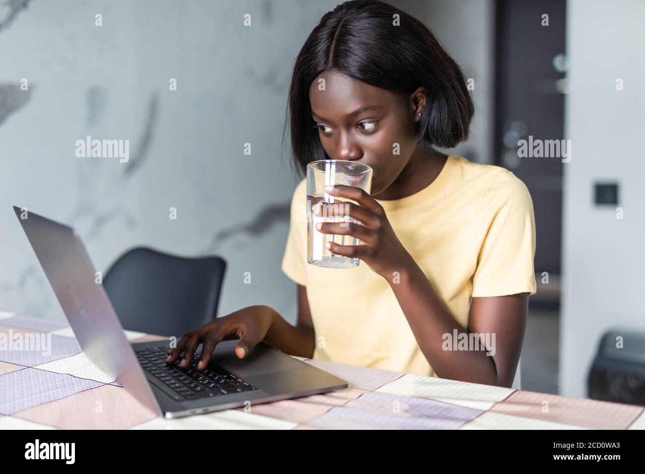 beautiful young black woman using laptop computer on kitchen counter ...
