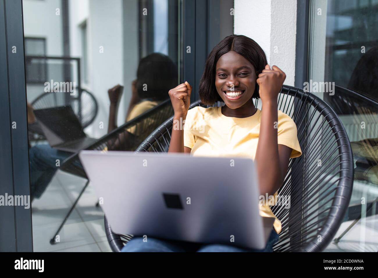 Portrait of cheerful freelancer looking at screen of laptop holding ...
