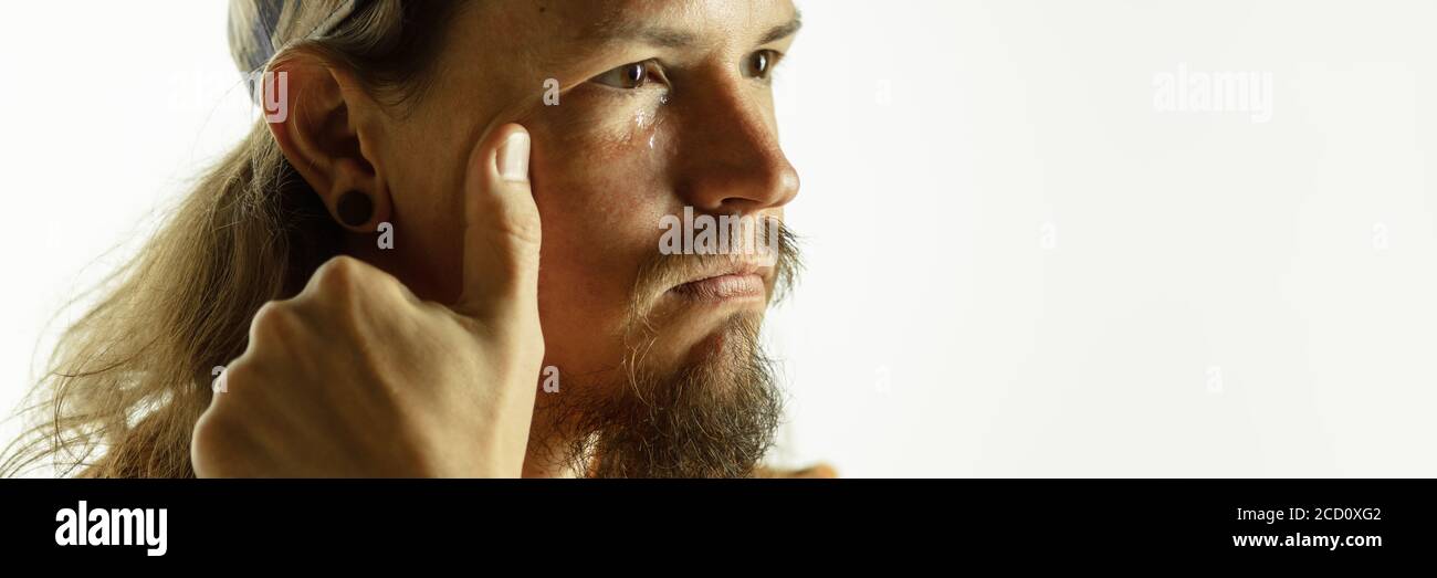 Crying. Caucasian young man's close up shot on studio background, flyer ...