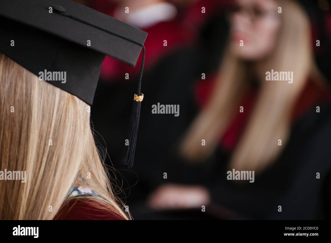 Young girl student waiting during graduation ceremony with her ...