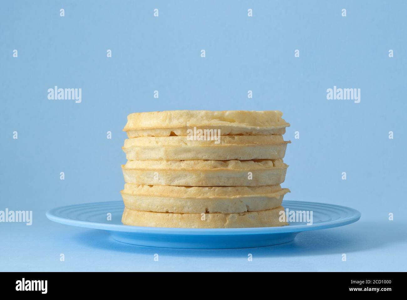 Round breakfast waffles stacked on blue plate Stock Photo - Alamy