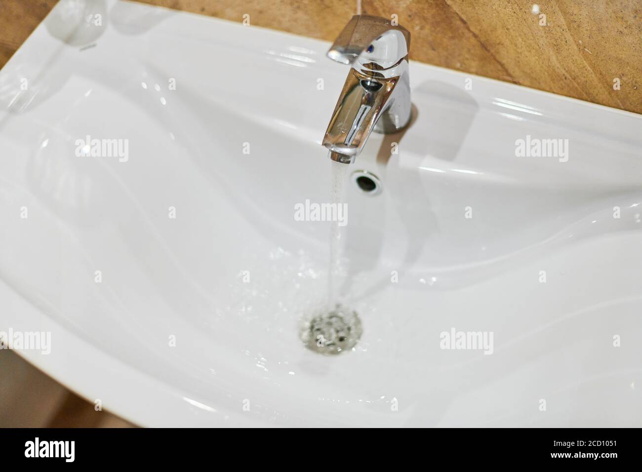 Faucet in bathroom interior. Opened water tap for washing hands from ...