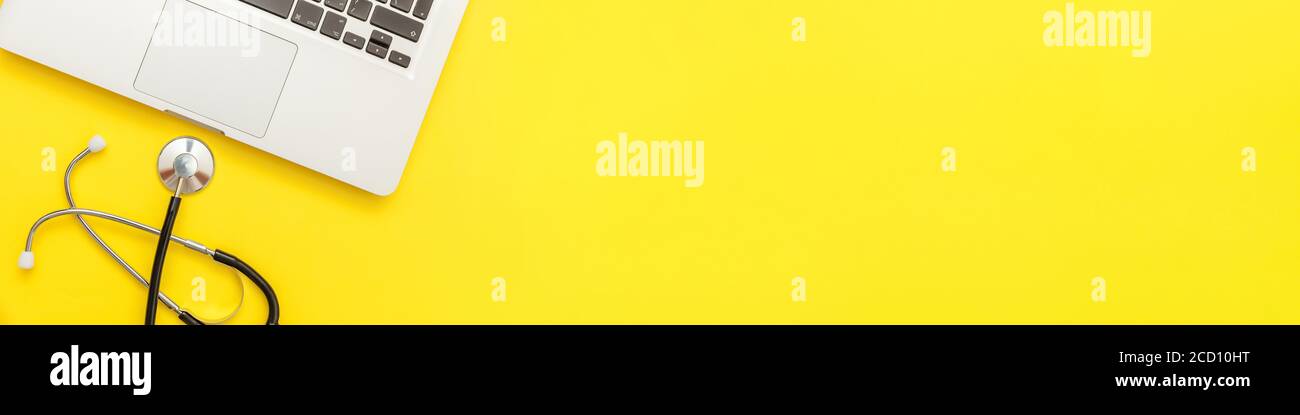 Stethoscope keyboard laptop computer isolated on yellow background ...