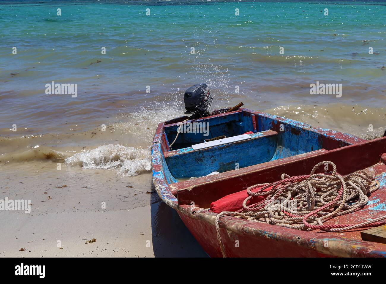 Old boat with a motor on the seashore Stock Photo - Alamy