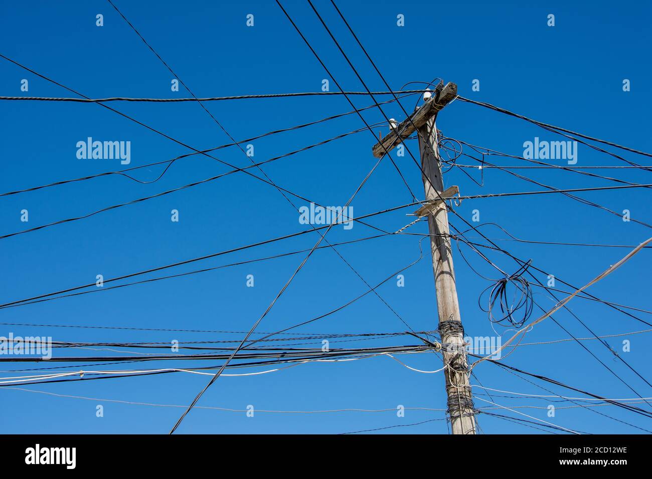 Electric pole with cables tangled in an anarchic manner. Concept of ...