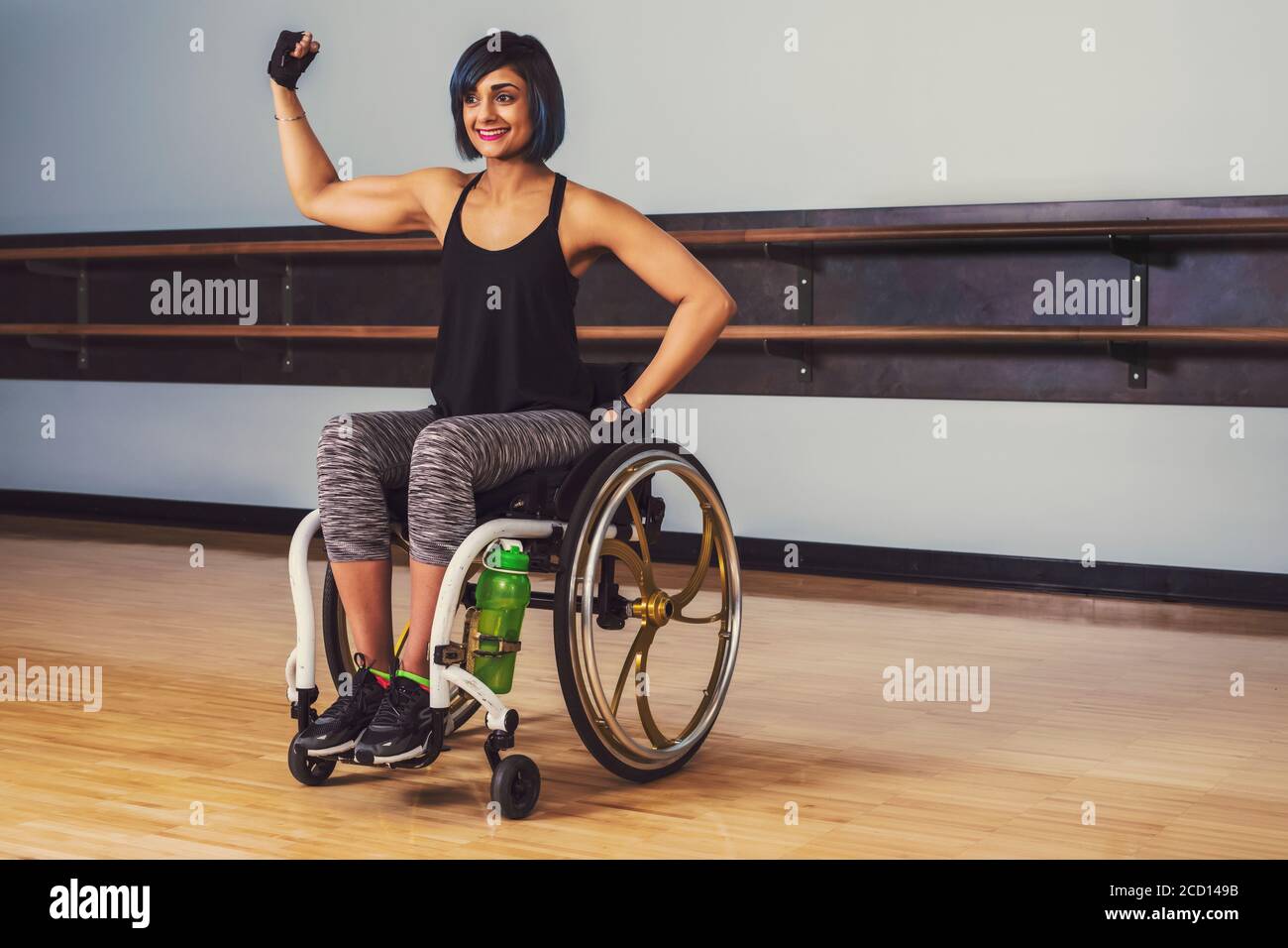 A paraplegic woman taking a break in a gymnasium after working out in a ...