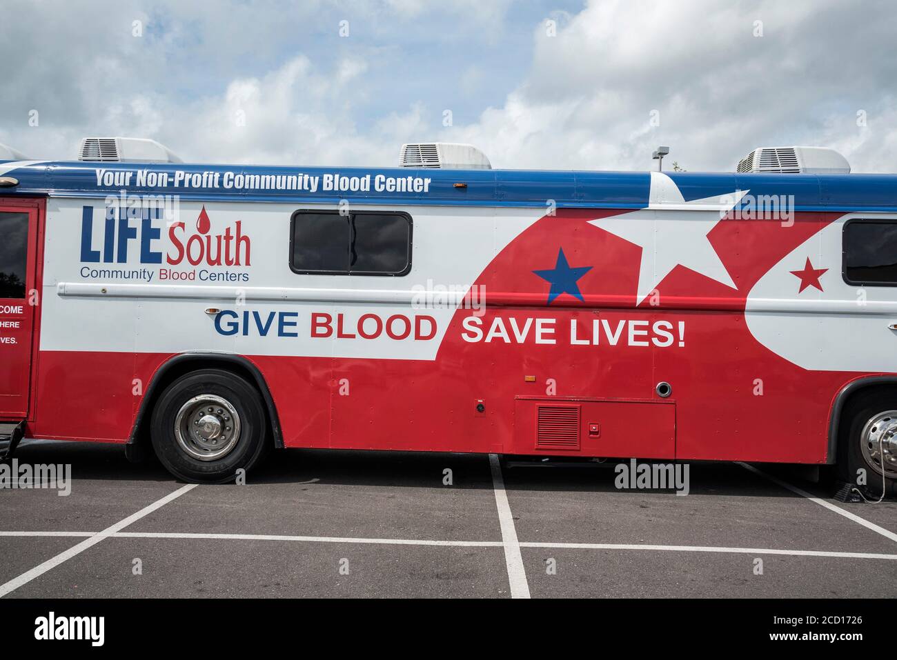 Bloodmobile parked in a shopping center parking lot is offering free ...