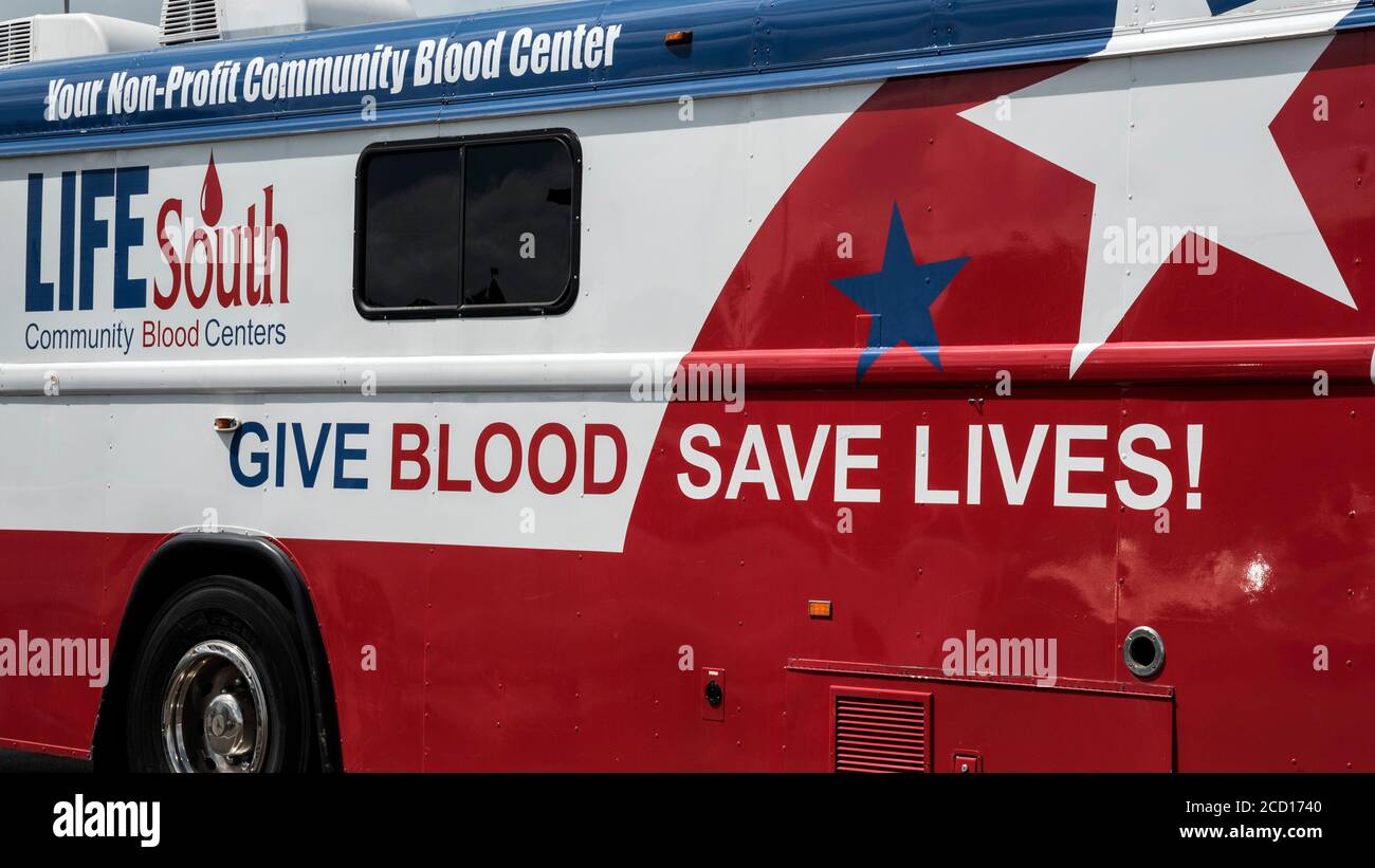Bloodmobile parked in a shopping center parking lot is offering free ...