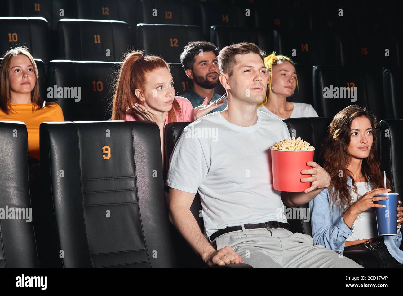 selfish tall guy eating popcorn loudly, woman is arguing his. close up ...