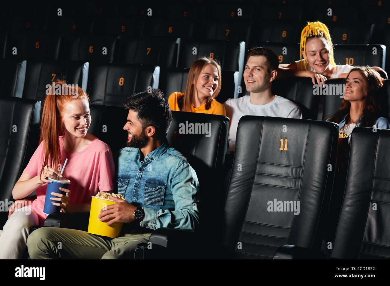 young man and woman laughing, flirting while watching film. close up ...
