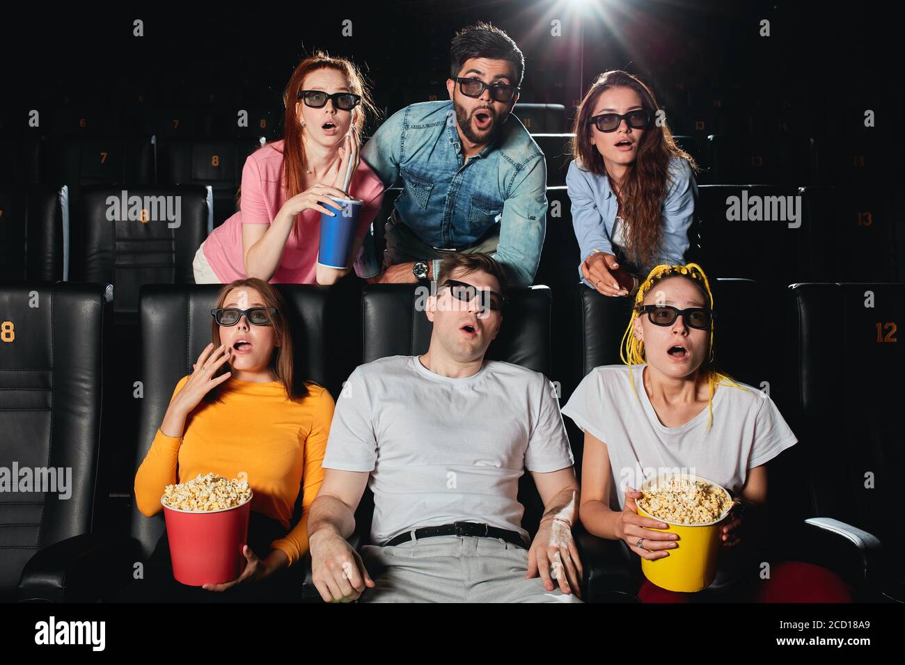 Portrait of an astonished group of young people staring at the screen ...