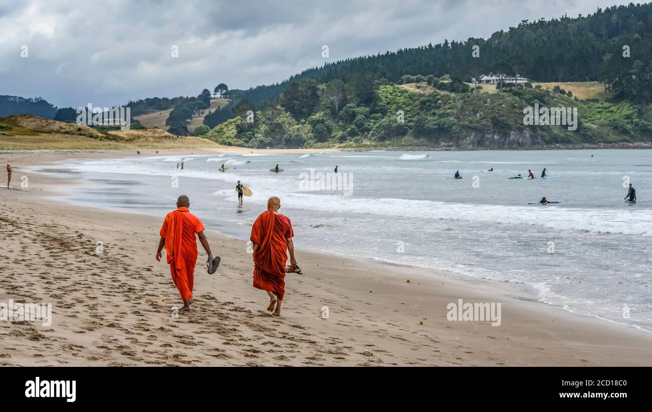 Buddhist Monks walking on the sand of Hot Water Beach. An underground ...