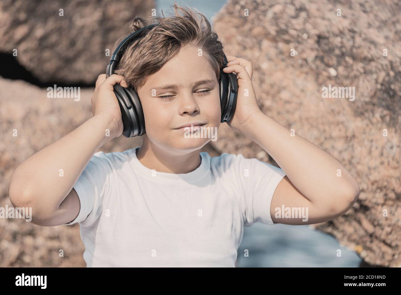 young boy with headphones listening to music outdoors Stock Photo - Alamy