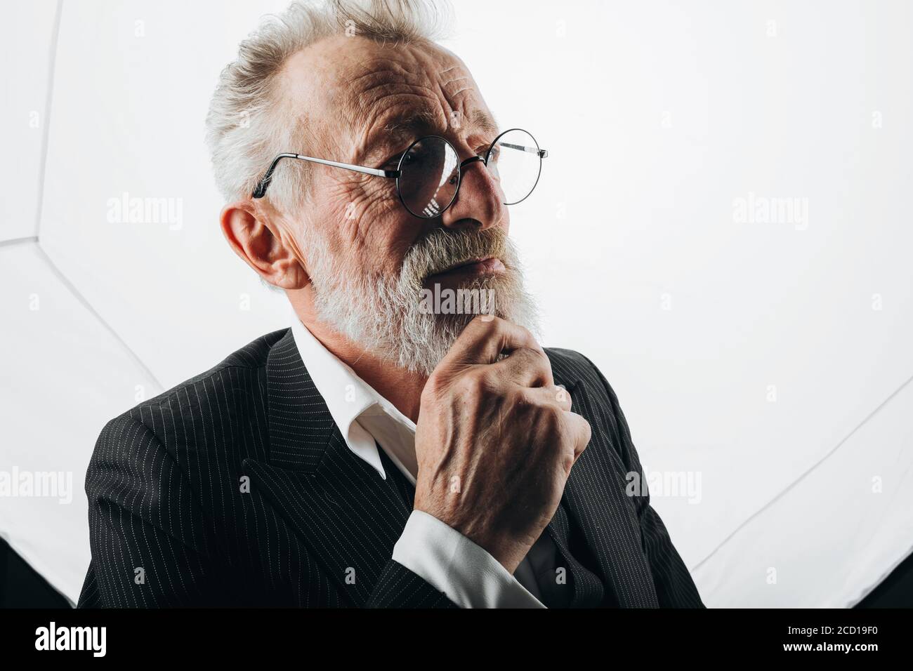 Portrait of handsome elderly intelligent professor in his 70s listening ...