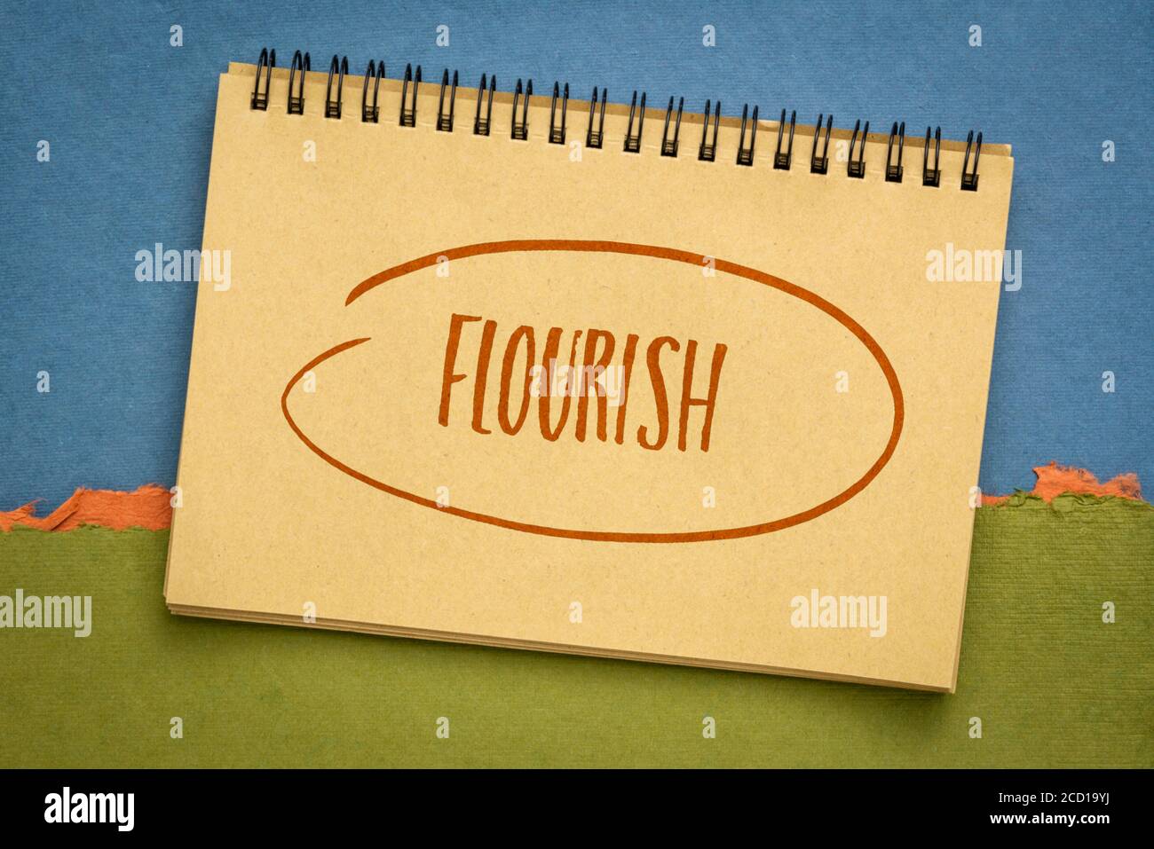 flourish - inspirational writing in a spiral sketchbook against ...