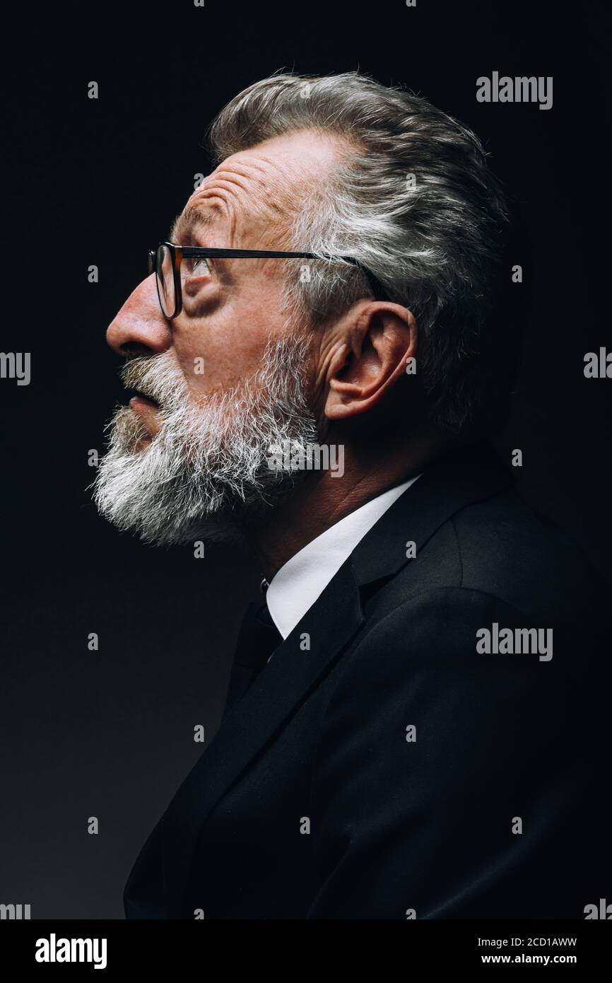 Handsome old aged thoughtful businessman in classic suit is looking ...