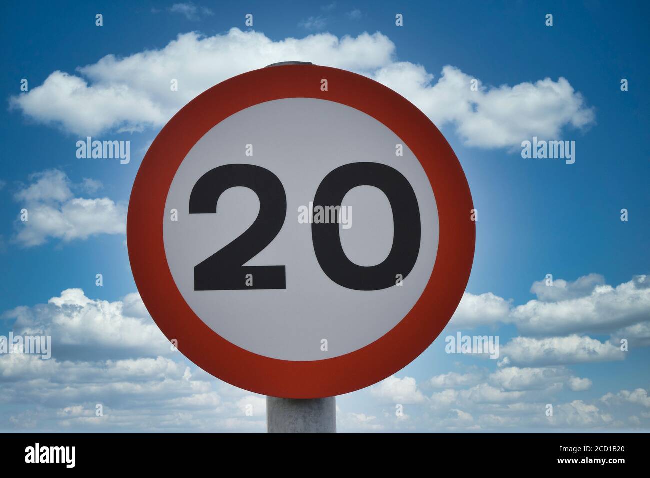 Circular road sign with twenty speed limit, isolated with blue sky and ...