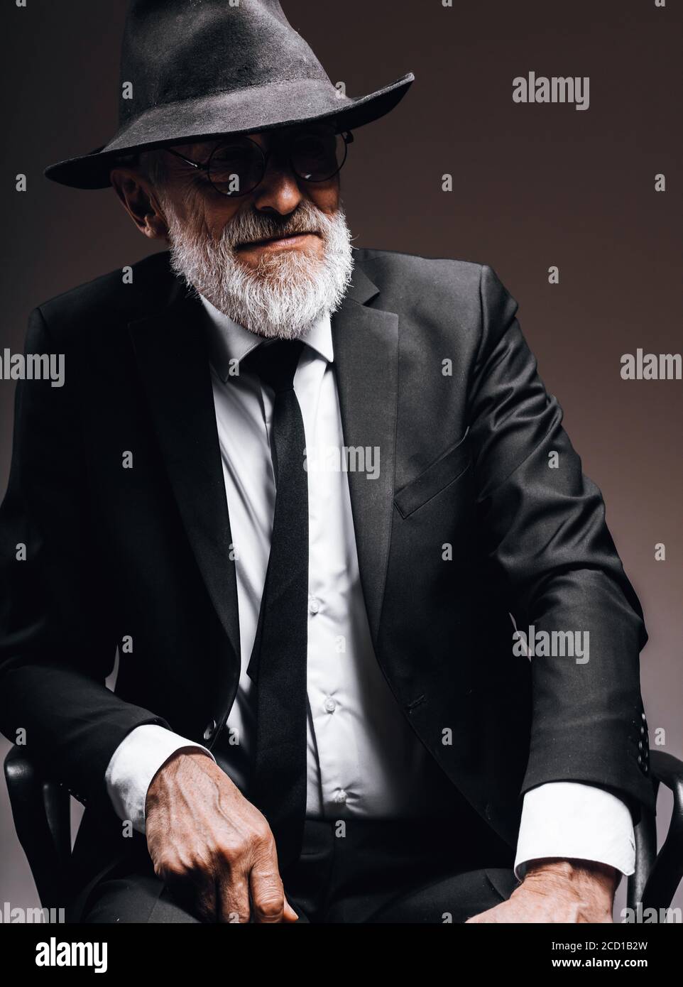 Elegantly dressed elderly gentleman portrait in classic style in trilby ...