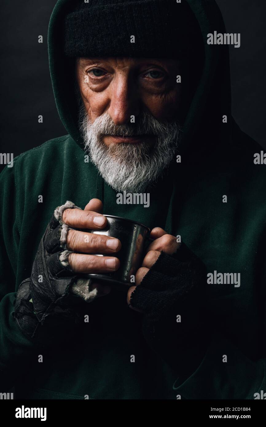 Frozen homeless bearded old man with grey hair and wrinkled face, looks ...