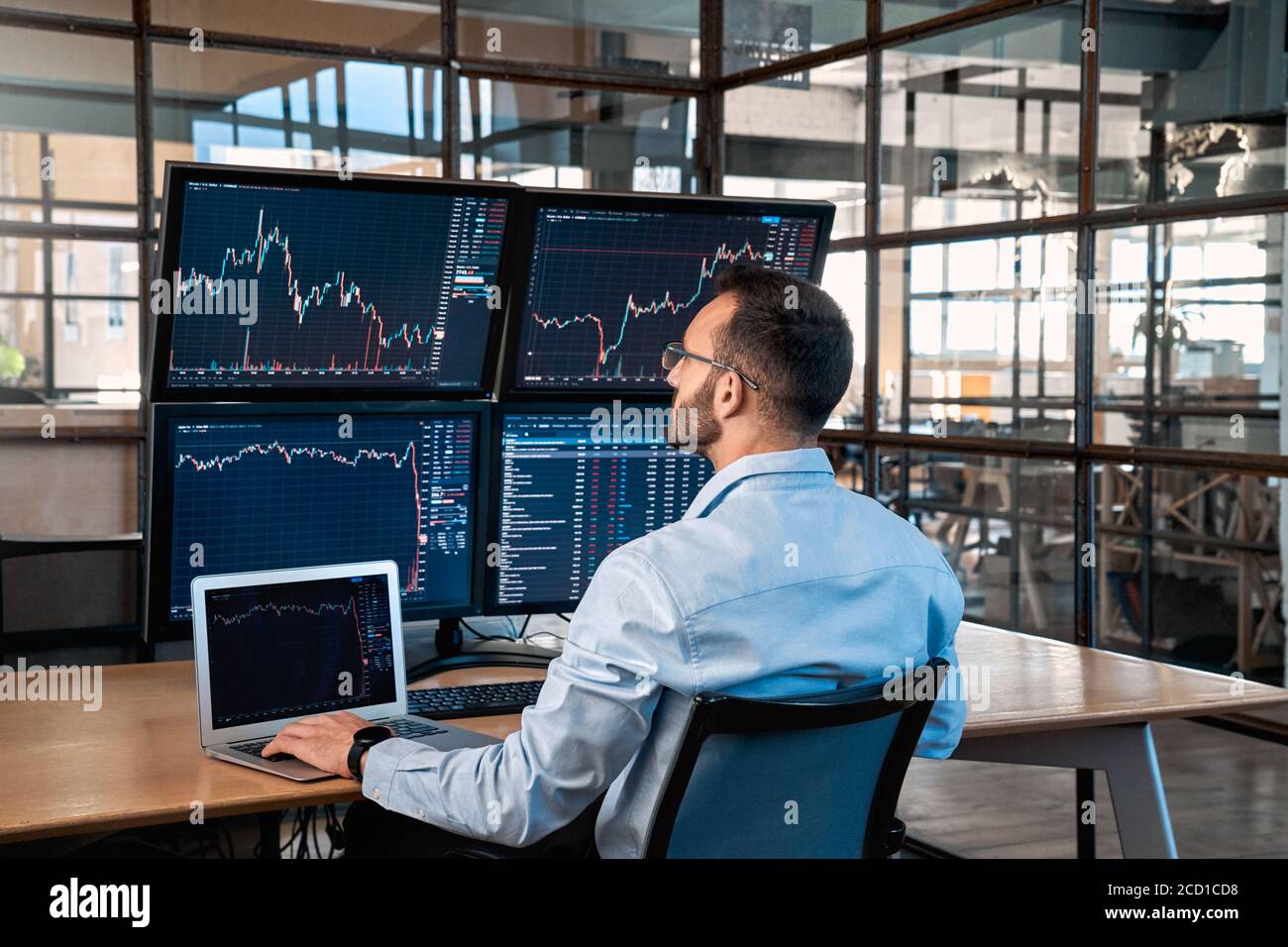Stock Traiding. Trader sitting at office analyzing price flow on ...