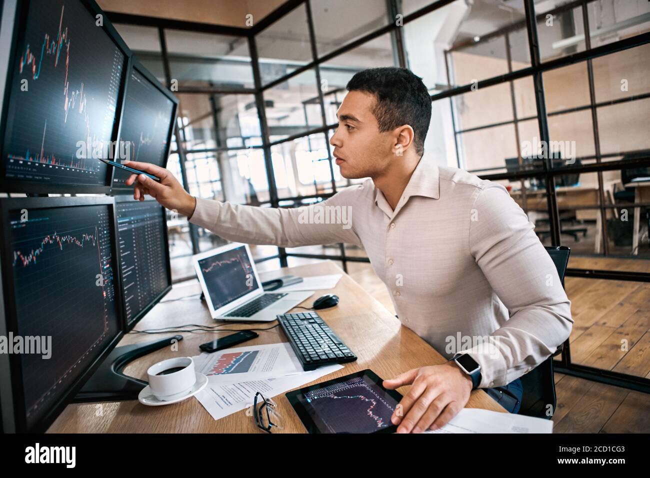 Stock Traiding. Trader sitting at office in front of monitors with data ...