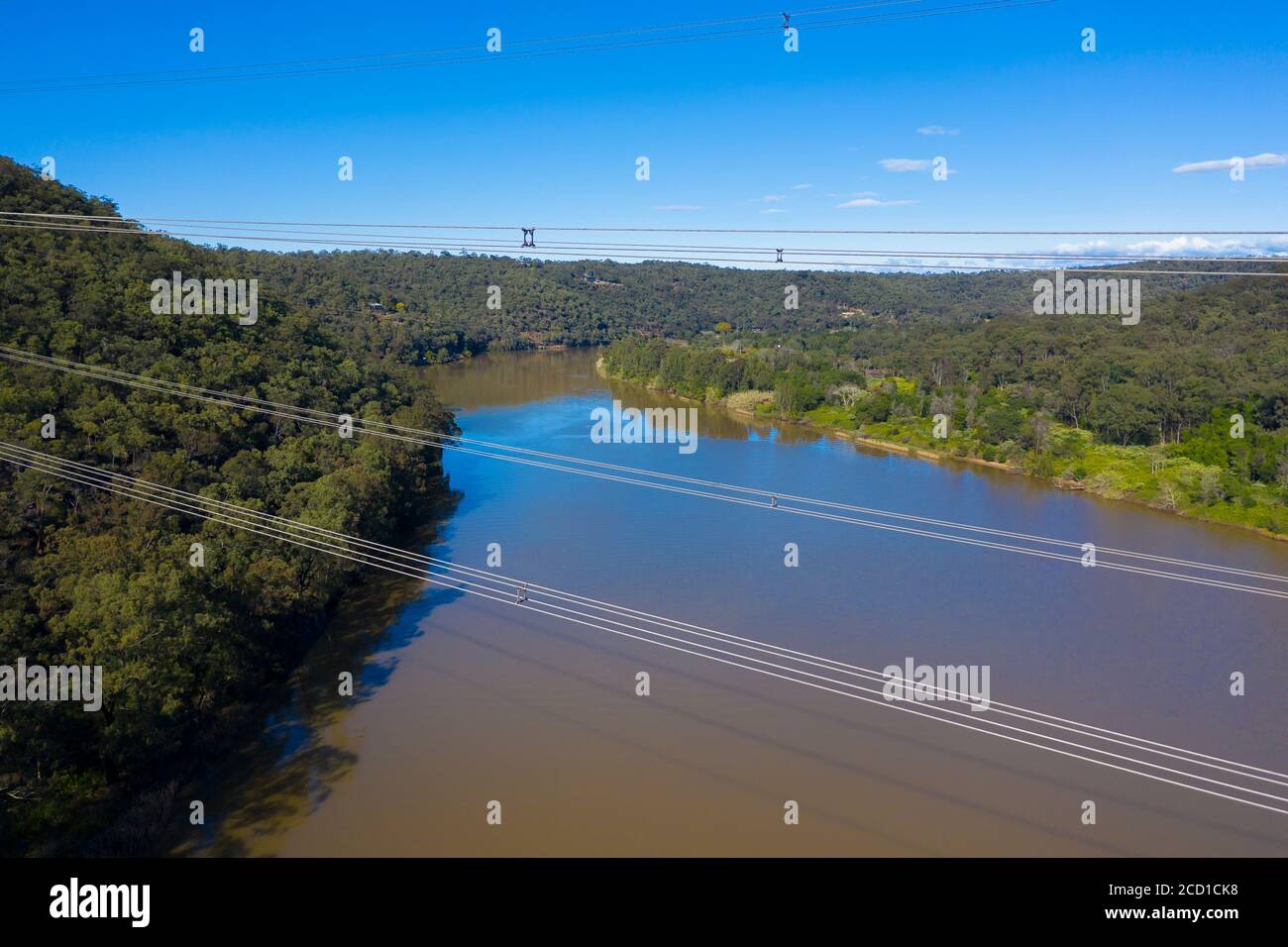 An electricity transmission tower and cables across a river in regional ...