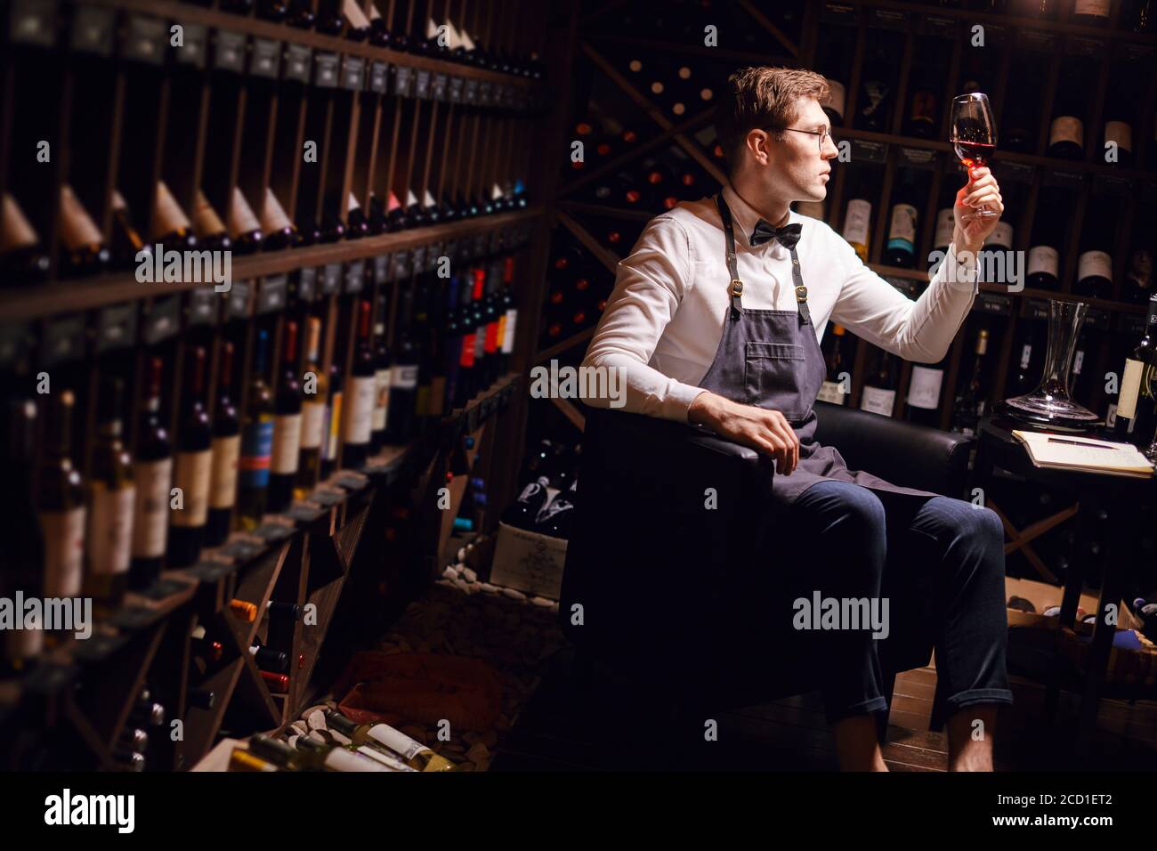 Wine critic appreciating color tint, quality and sediments of drink in ...