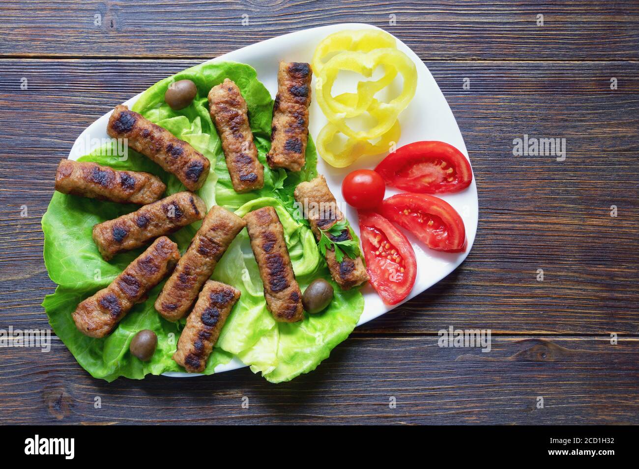 Balkan cuisine. Cevapi - grilled dish of minced meat on rustic table ...