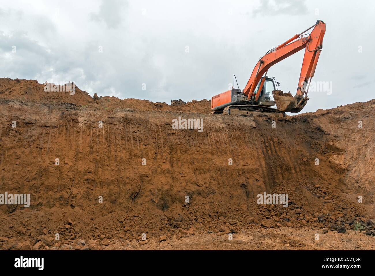 The construction site excavator digs a deep pit. Digger. Construction ...