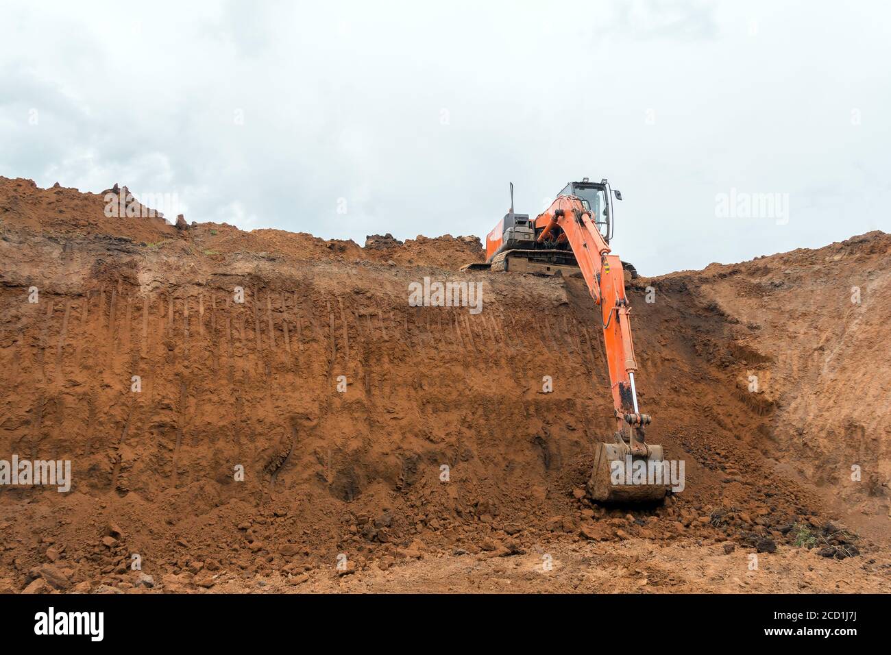 The construction site excavator digs a deep pit. Digger. Construction ...