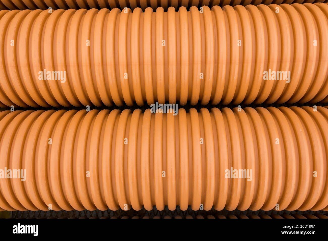 Sewer plastic pipes of orange color at a construction site ...