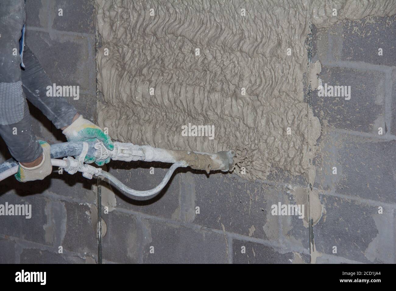 Machine application of plaster to the wall. Plasterer spraying plaster ...