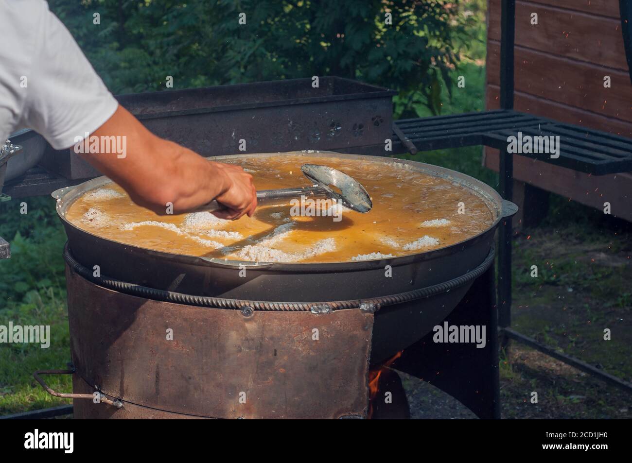 Cooking Uzbek pilaf. National food. Roasting meat in a large cauldron ...