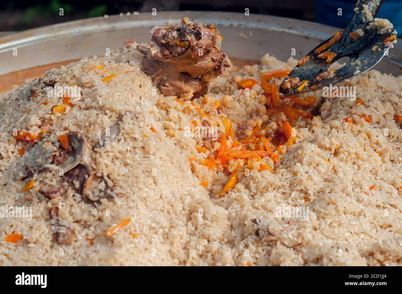 Cooking Uzbek pilaf. National food. Roasting meat in a large cauldron ...