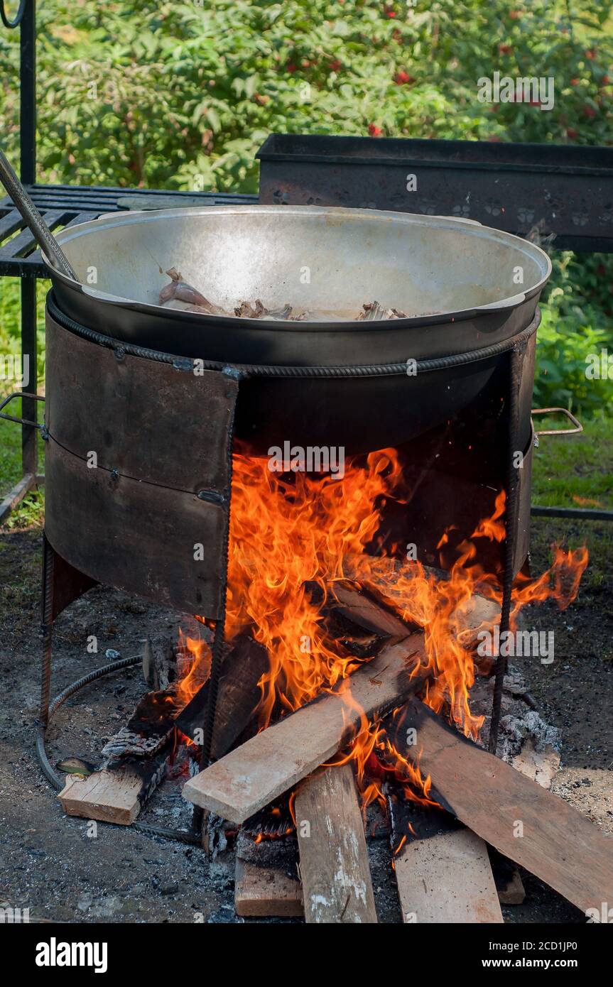 Cooking Uzbek pilaf. National food. Roasting meat in a large cauldron ...