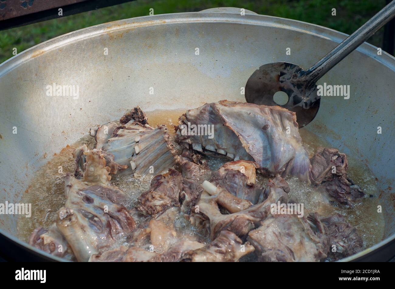 Cooking Uzbek pilaf. National food. Roasting meat in a large cauldron ...
