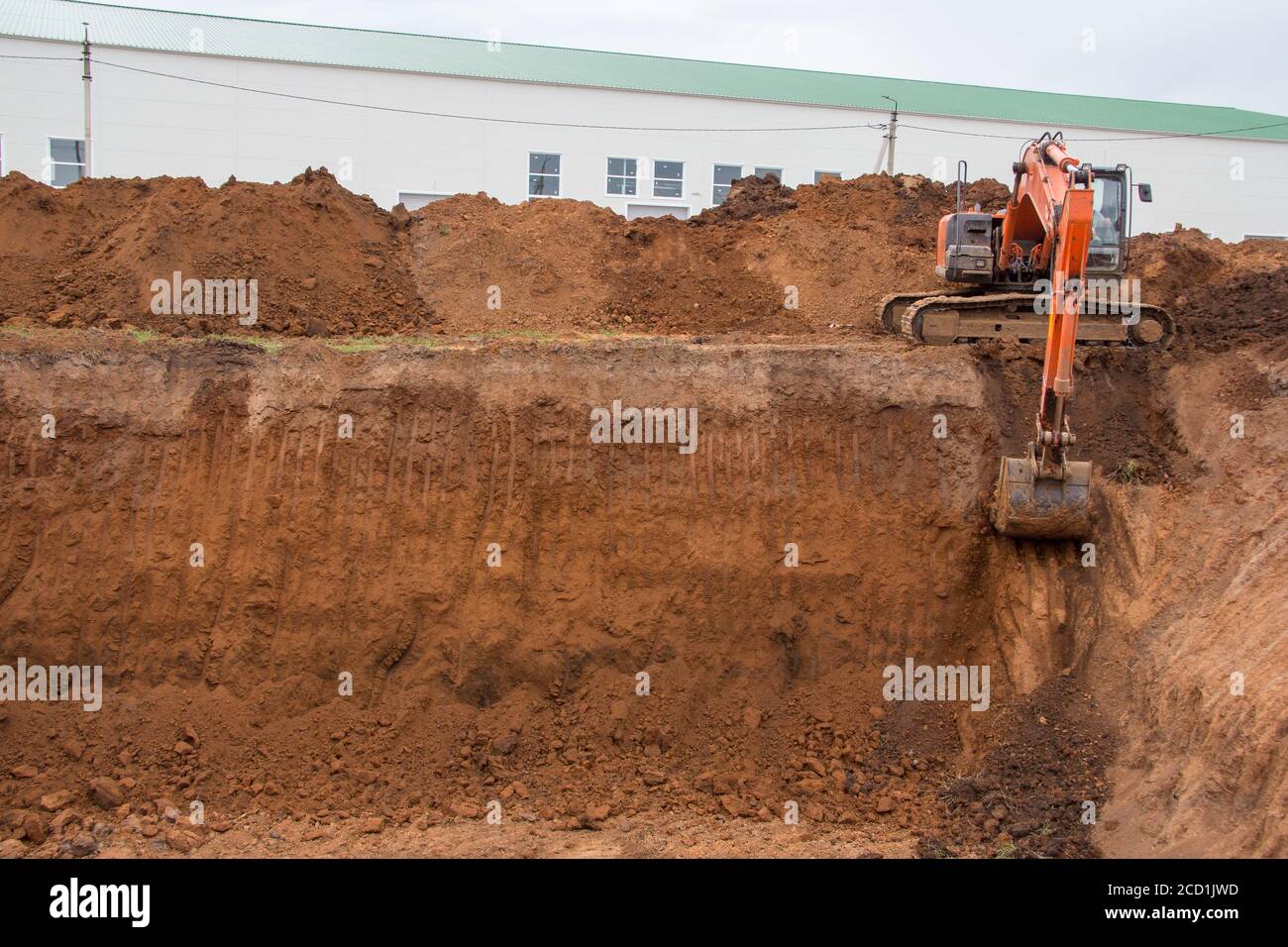 The construction site excavator digs a deep pit. Digger. Construction ...
