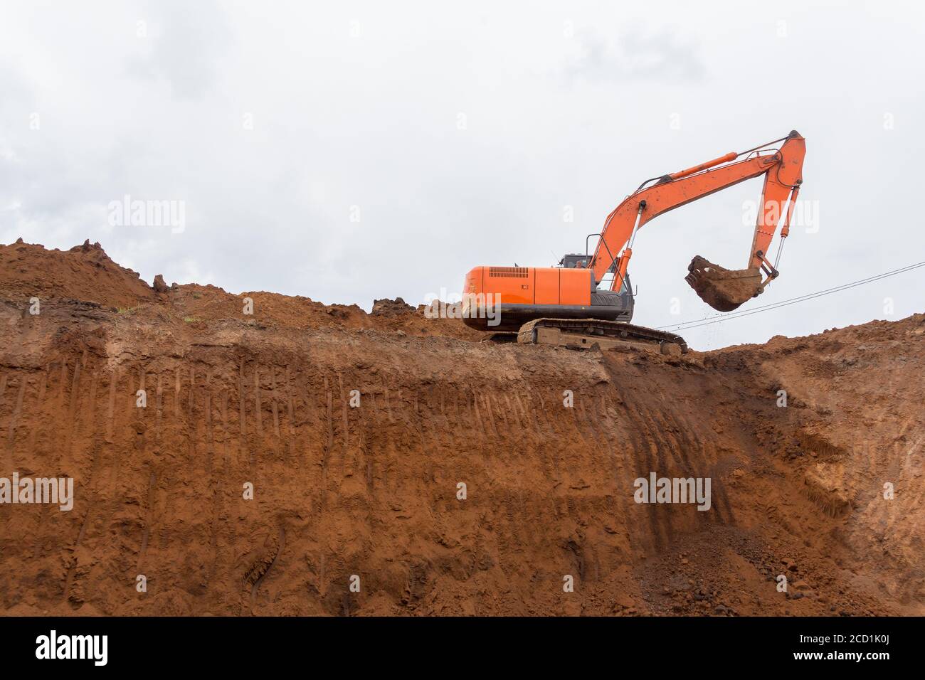 The construction site excavator digs a deep pit. Digger. Construction ...