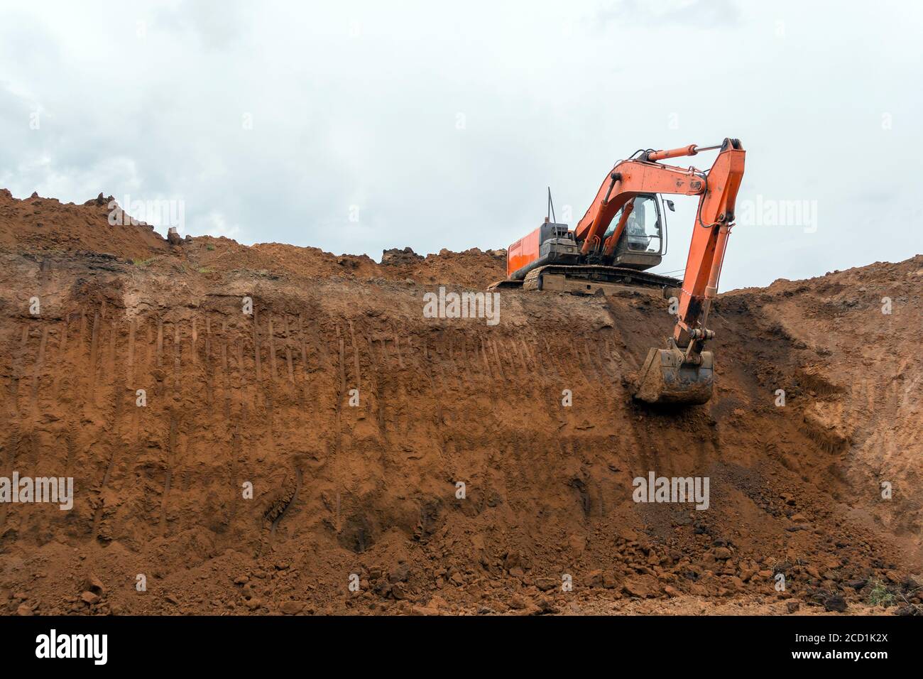 The construction site excavator digs a deep pit. Digger. Construction ...