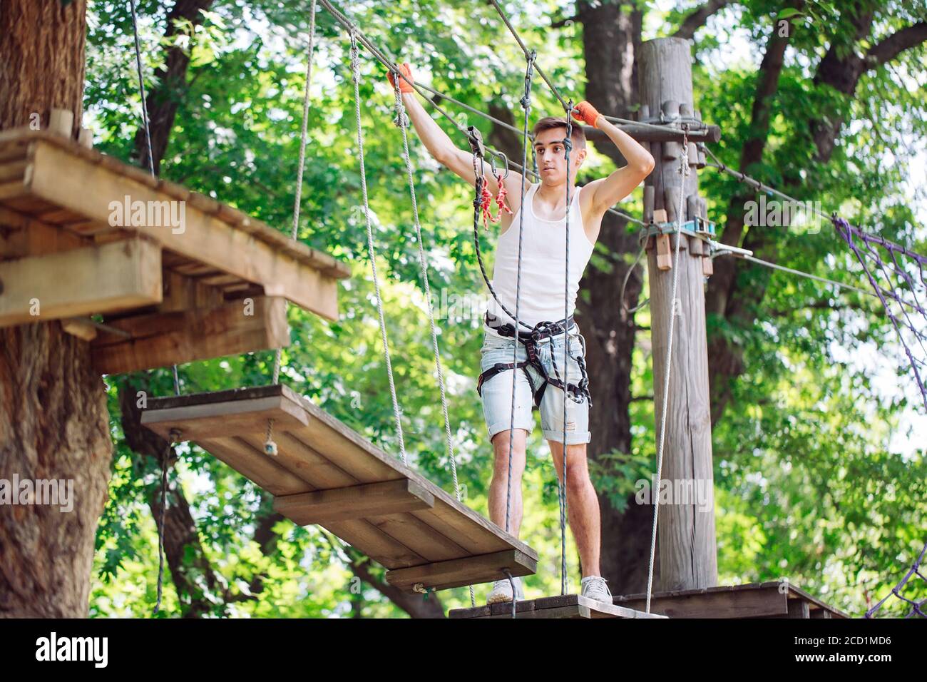 Man spend their leisure time in a ropes course. Man engaged in rope ...