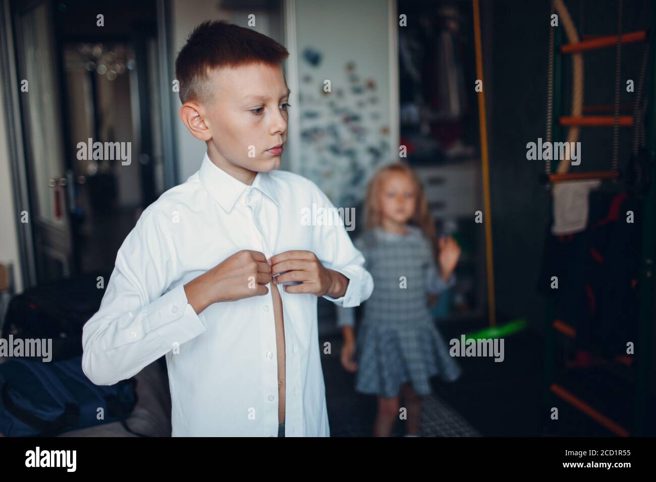 Young boy and his little sister dressing uniform preparation back to ...