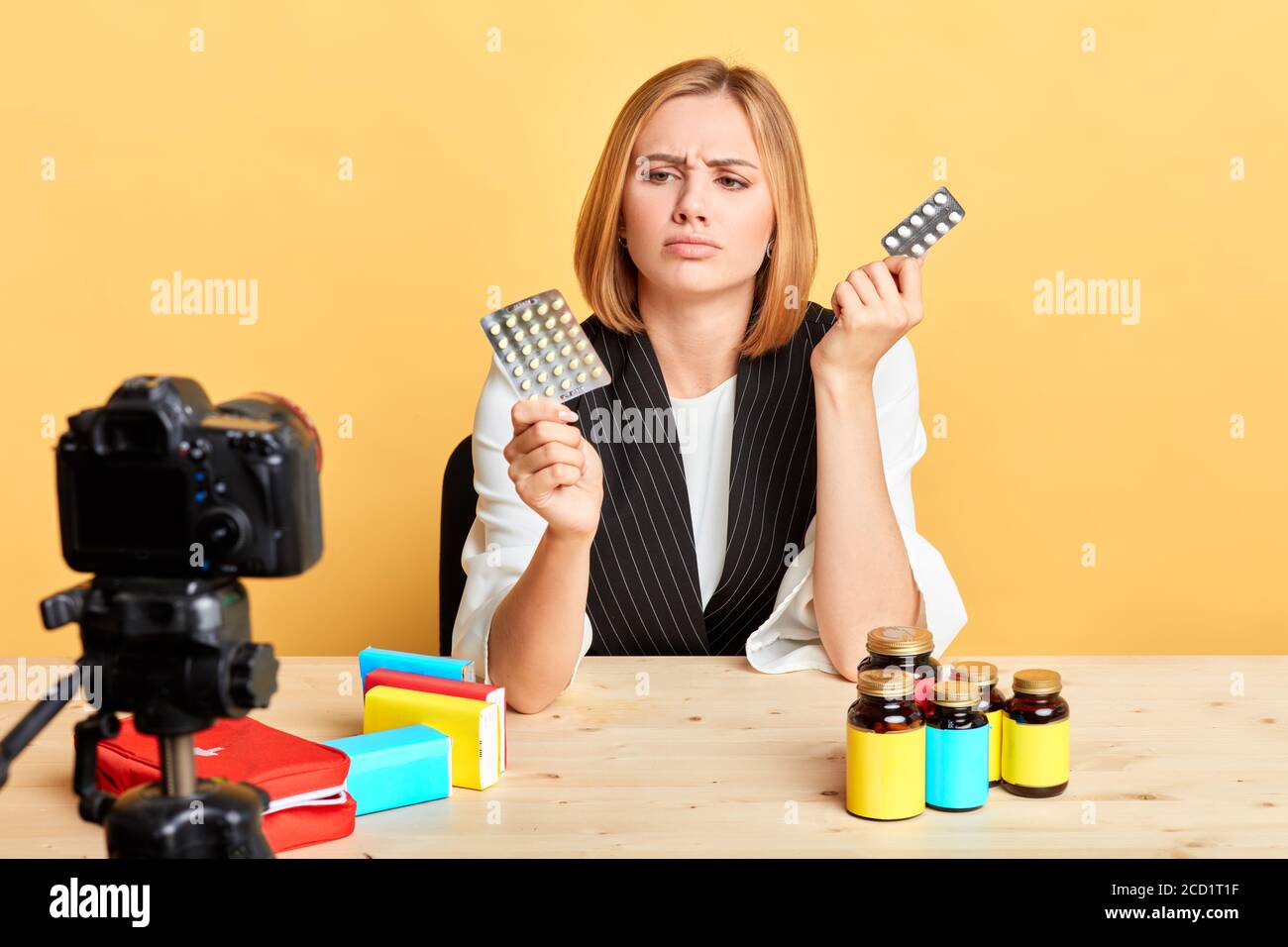 Thoughtful pretty blogger girl has headache, chooses what pill is ...