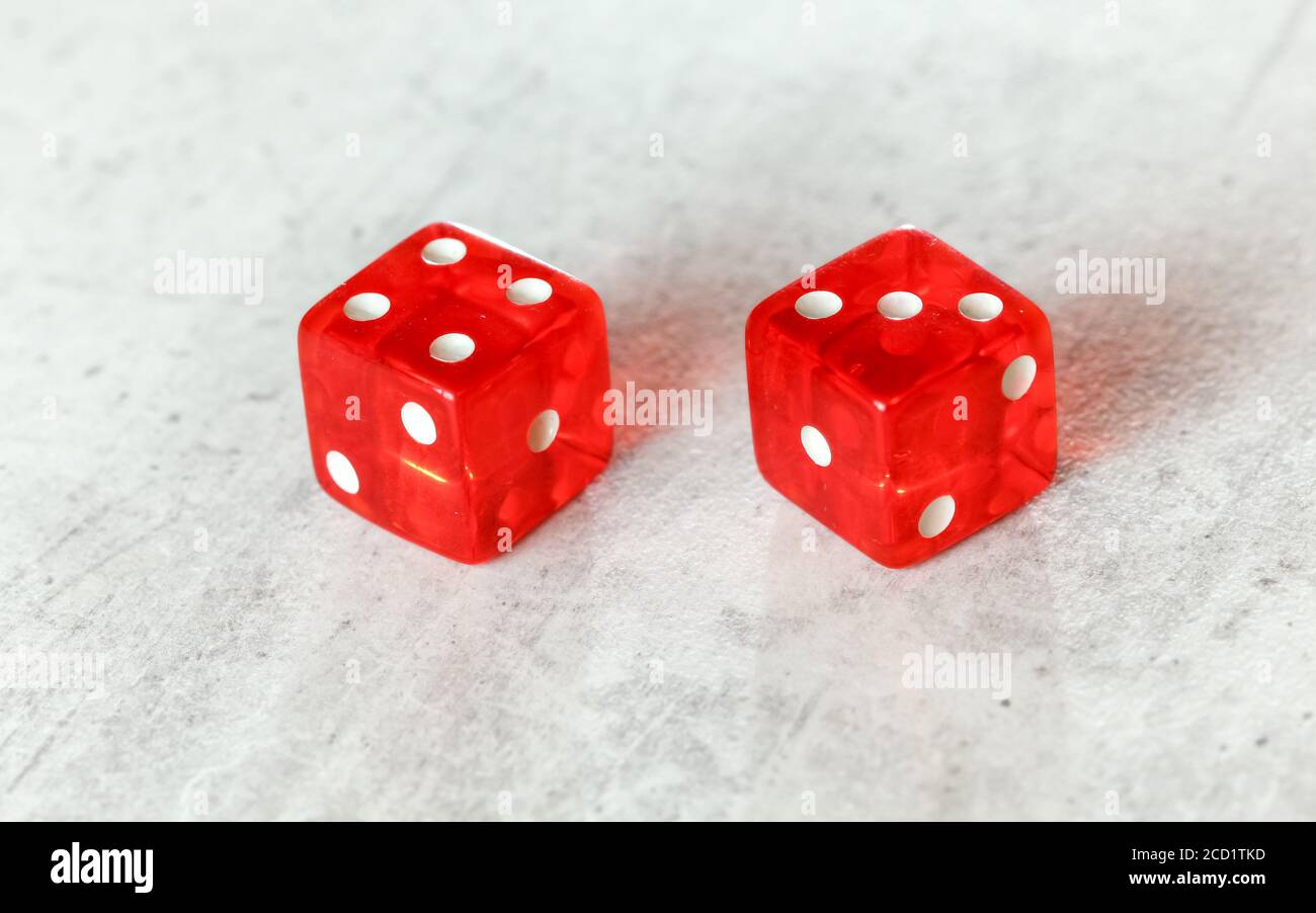 Two translucent red craps dices on white board showing Natural or Seven ...