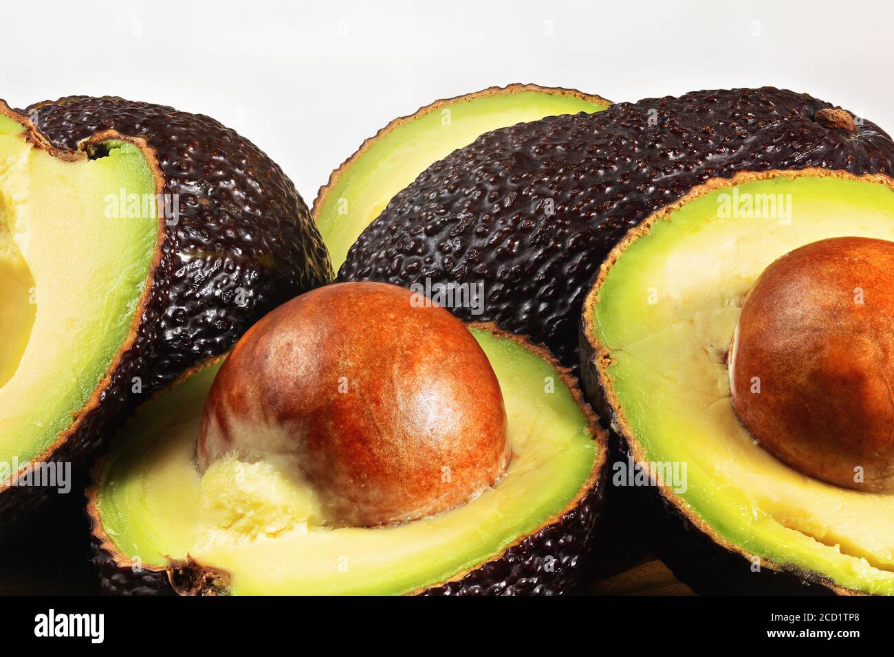 Detail of avocado halves, yellow and green pulp with dark skin - Hass ...