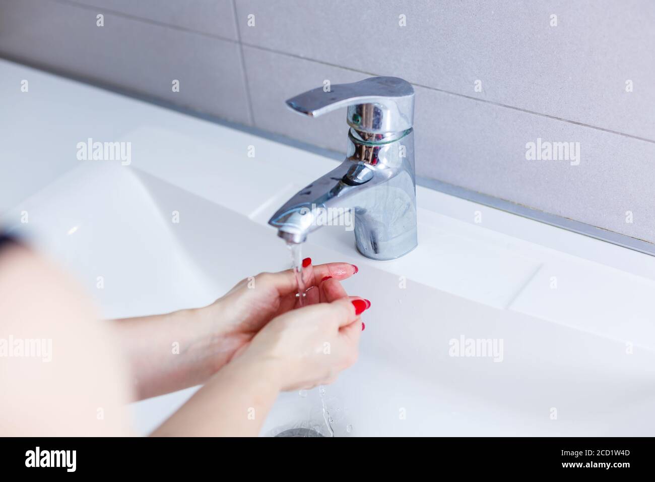 Washing woman hands with streaming water under tap in bathroom,washing ...